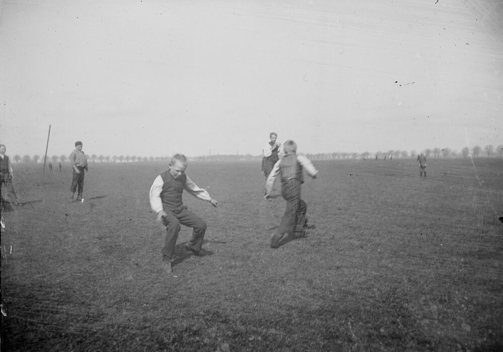 Drenge spiller fodbold på græsmark - kbhbilleder.dk